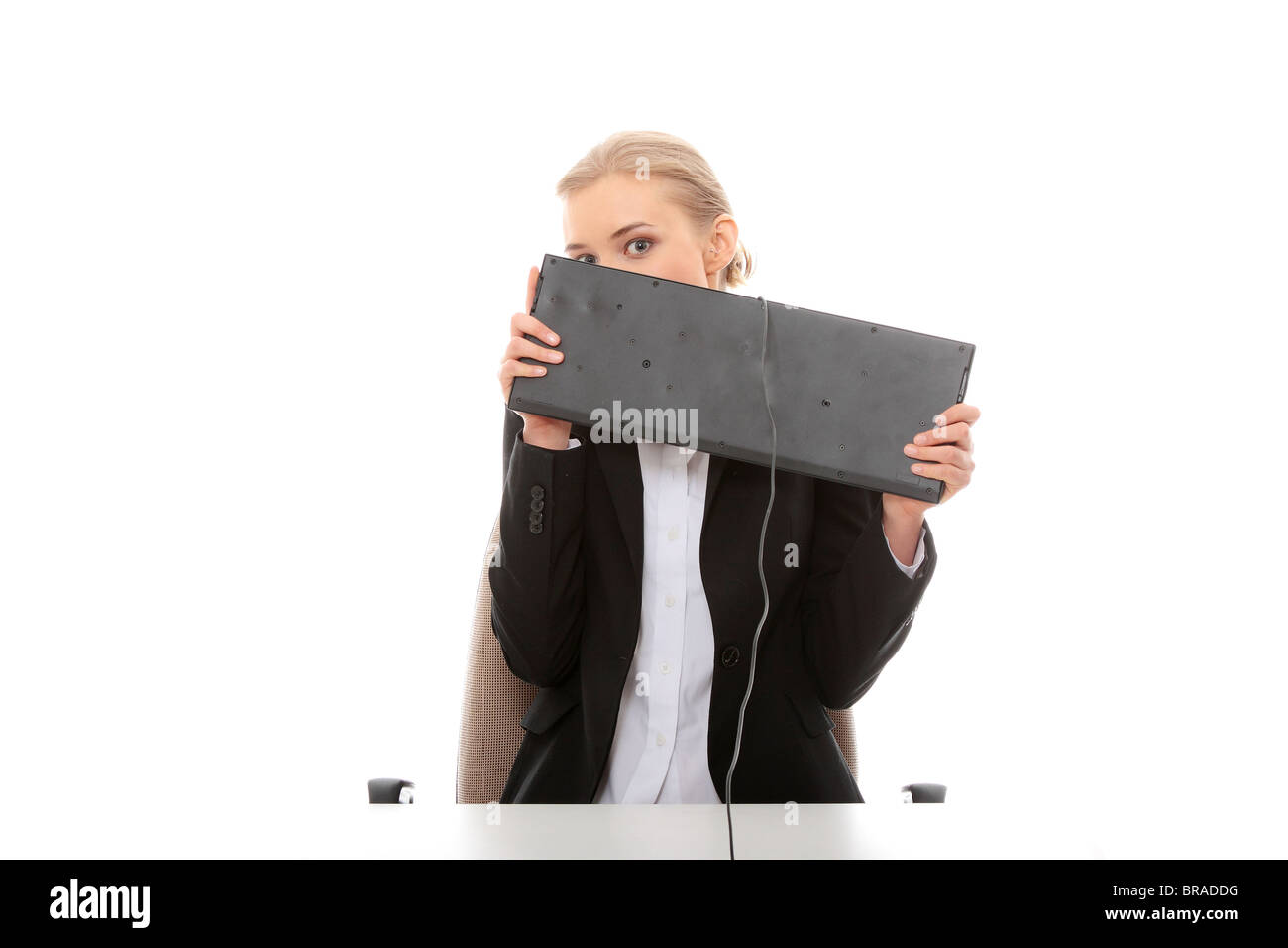 Scared business woman covering her face with keyboard, isolated on ...