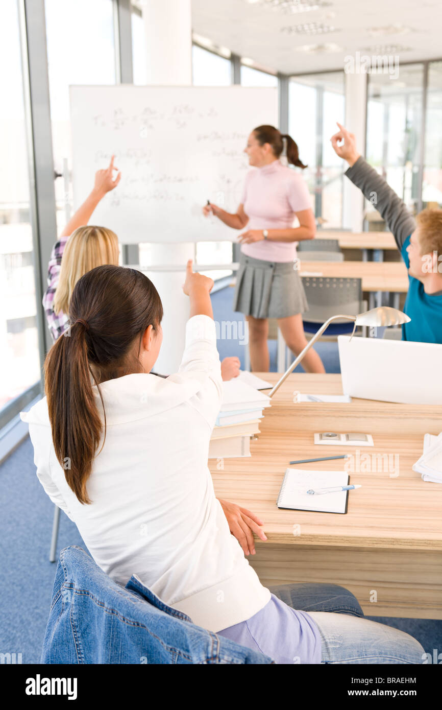 High school students raising hands, in classroom with professor Stock ...