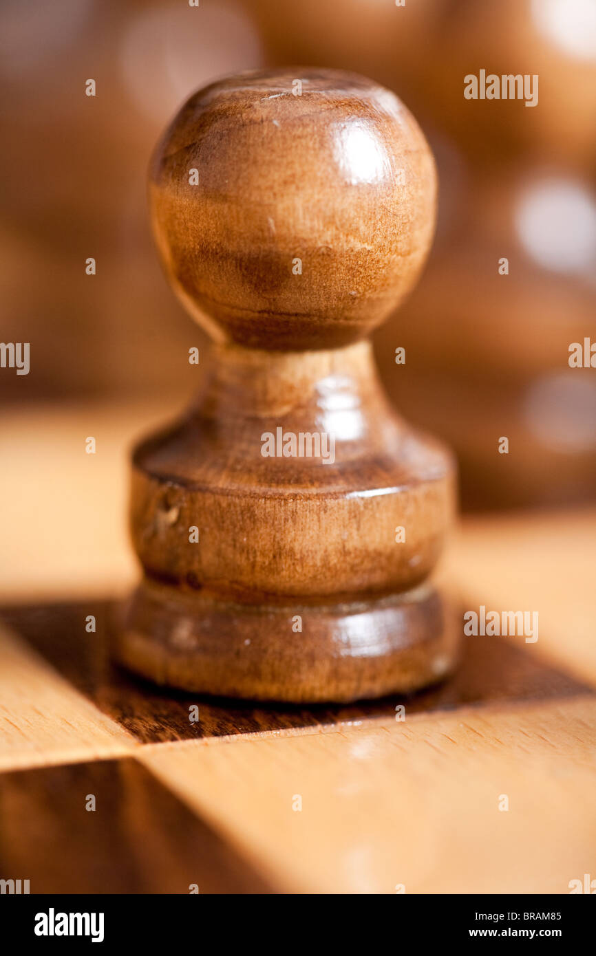 Pawn in front of chess pieces on a board, shallow depth of field Stock ...