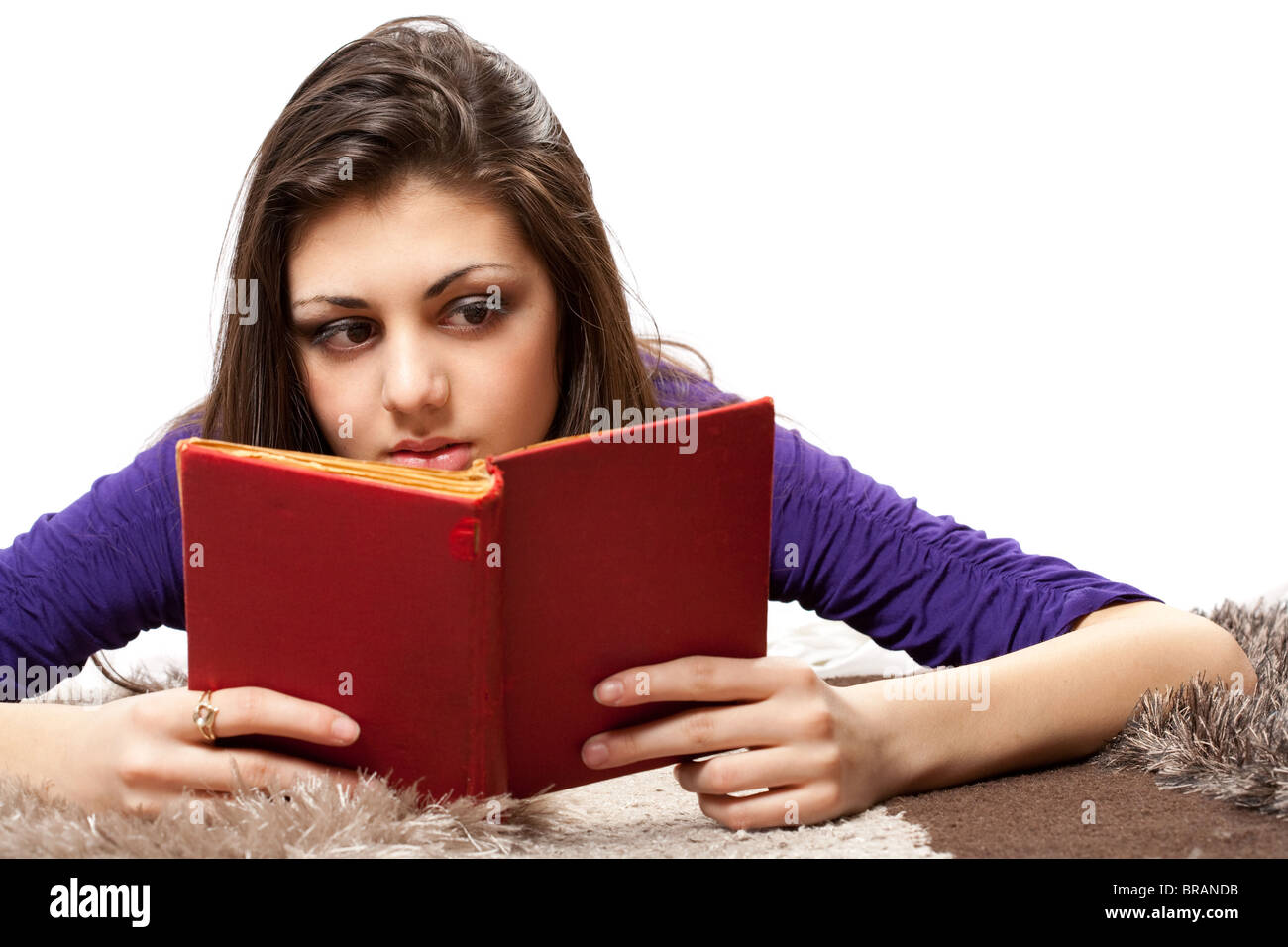 Cute girl reading a book on the carpet on the floor Stock Photo - Alamy