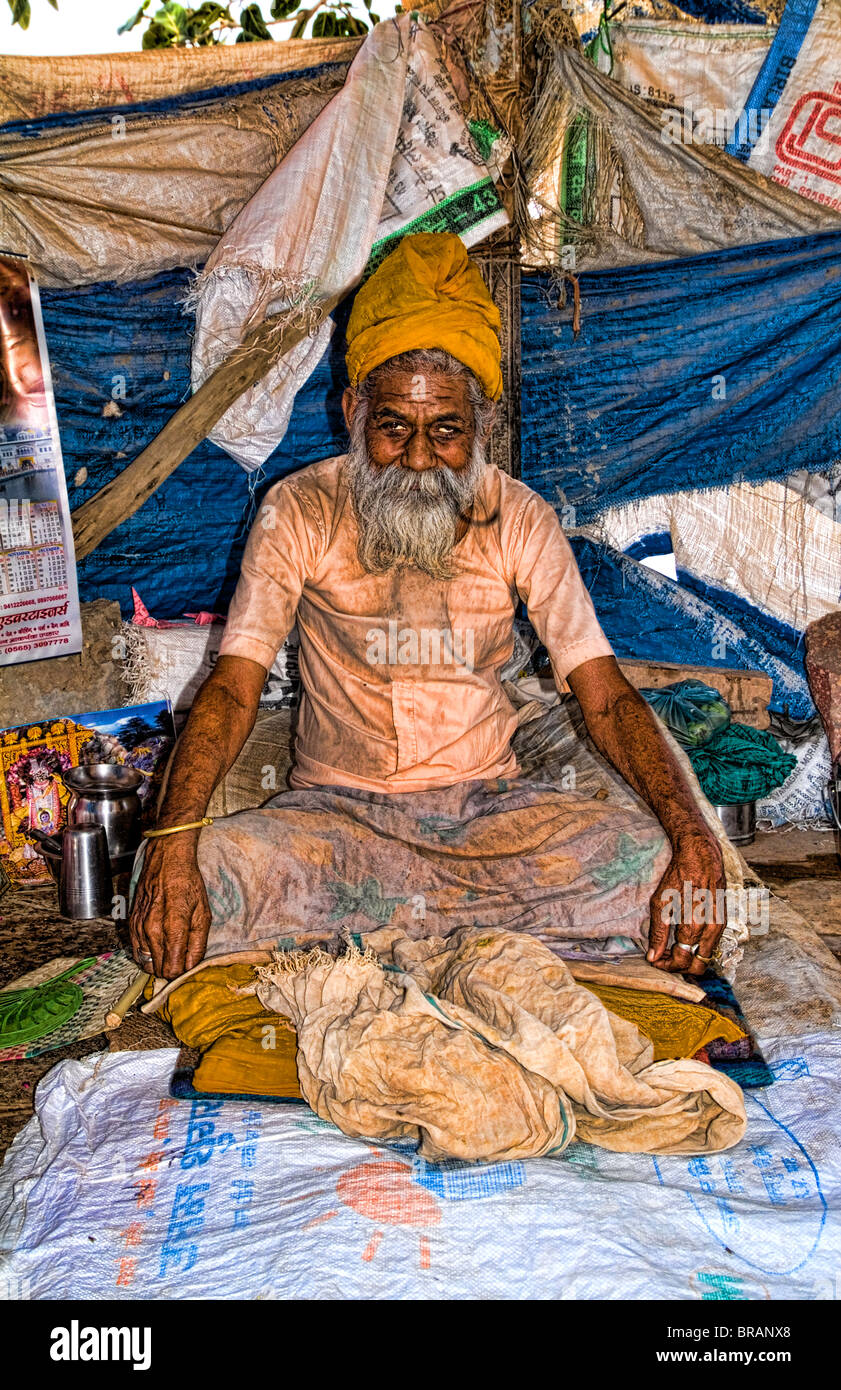 Older Hindu man in poor home by river in religious village of Mathura ...