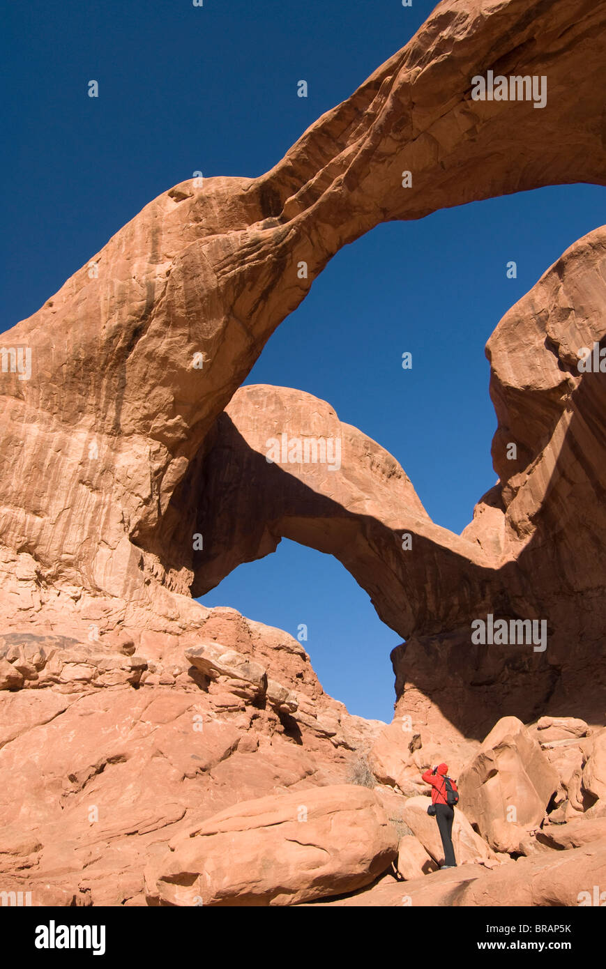 Double Arch and tourist taking a photograph, Arches National Park, Utah ...