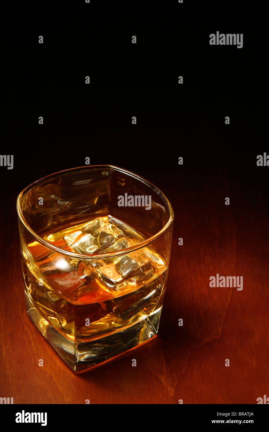 Whiskey in light pool on brown table with copyspace Stock Photo - Alamy