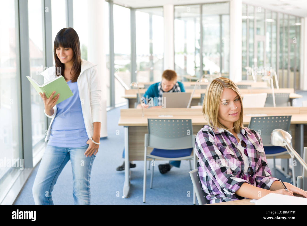 Student reading book in classroom at university Stock Photo - Alamy