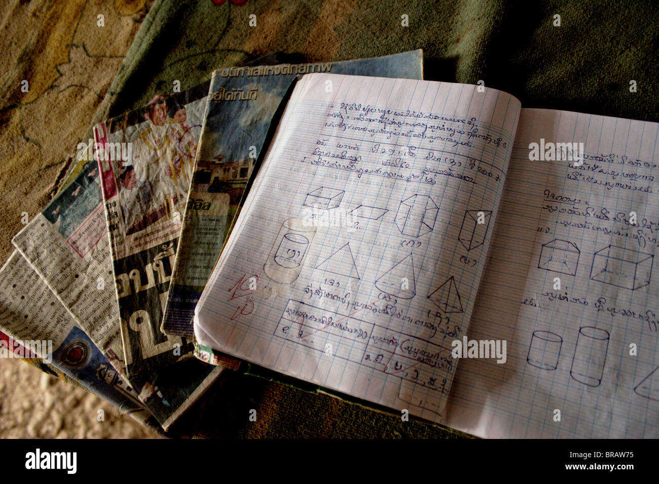 A student's workbook displaying a perfect mathematics score rests on a ...