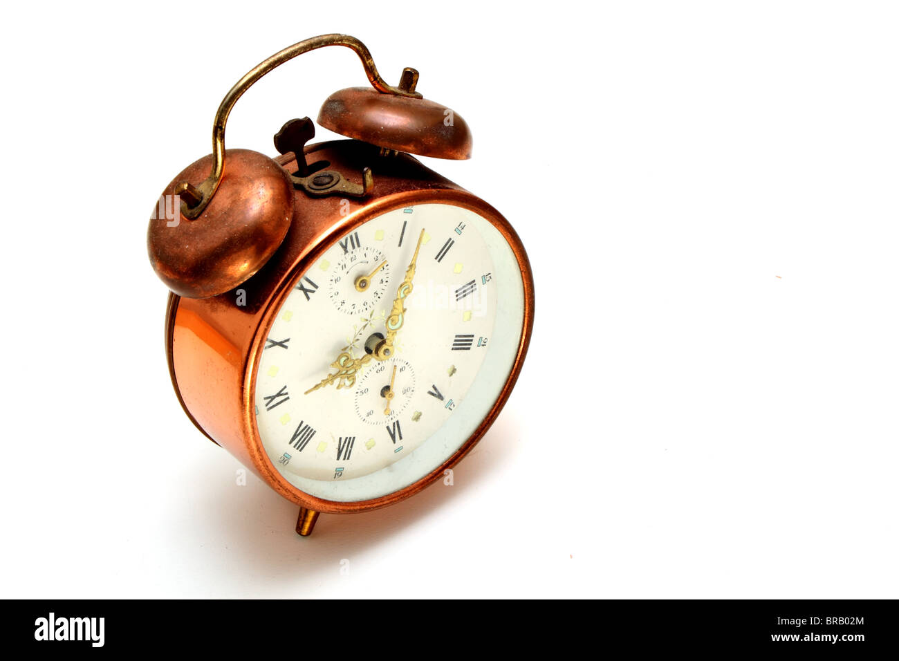 Copper alarm clock over white background Stock Photo - Alamy