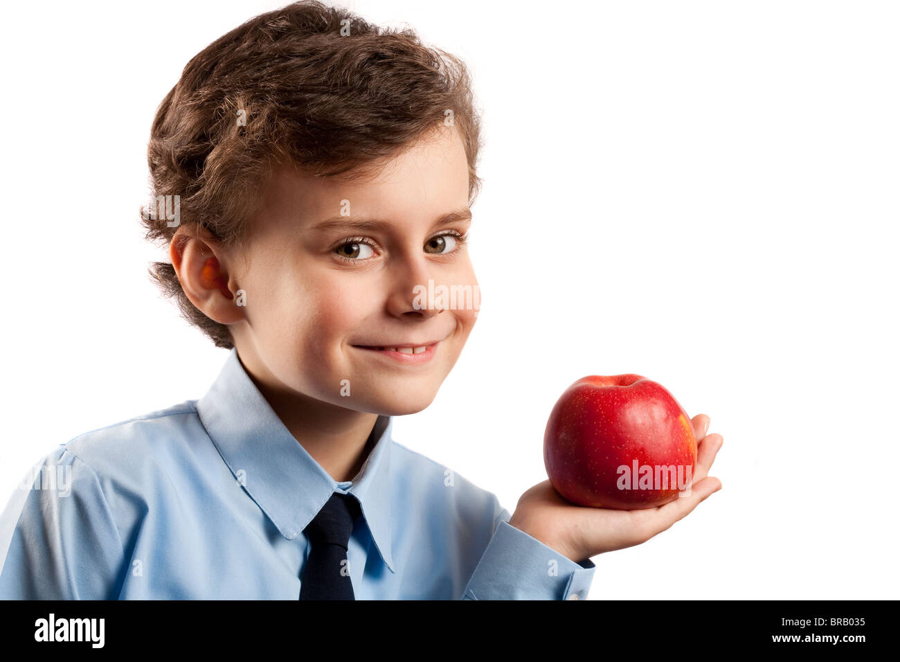 Cute schoolboy having an apple in his lunch break, isolated on white ...