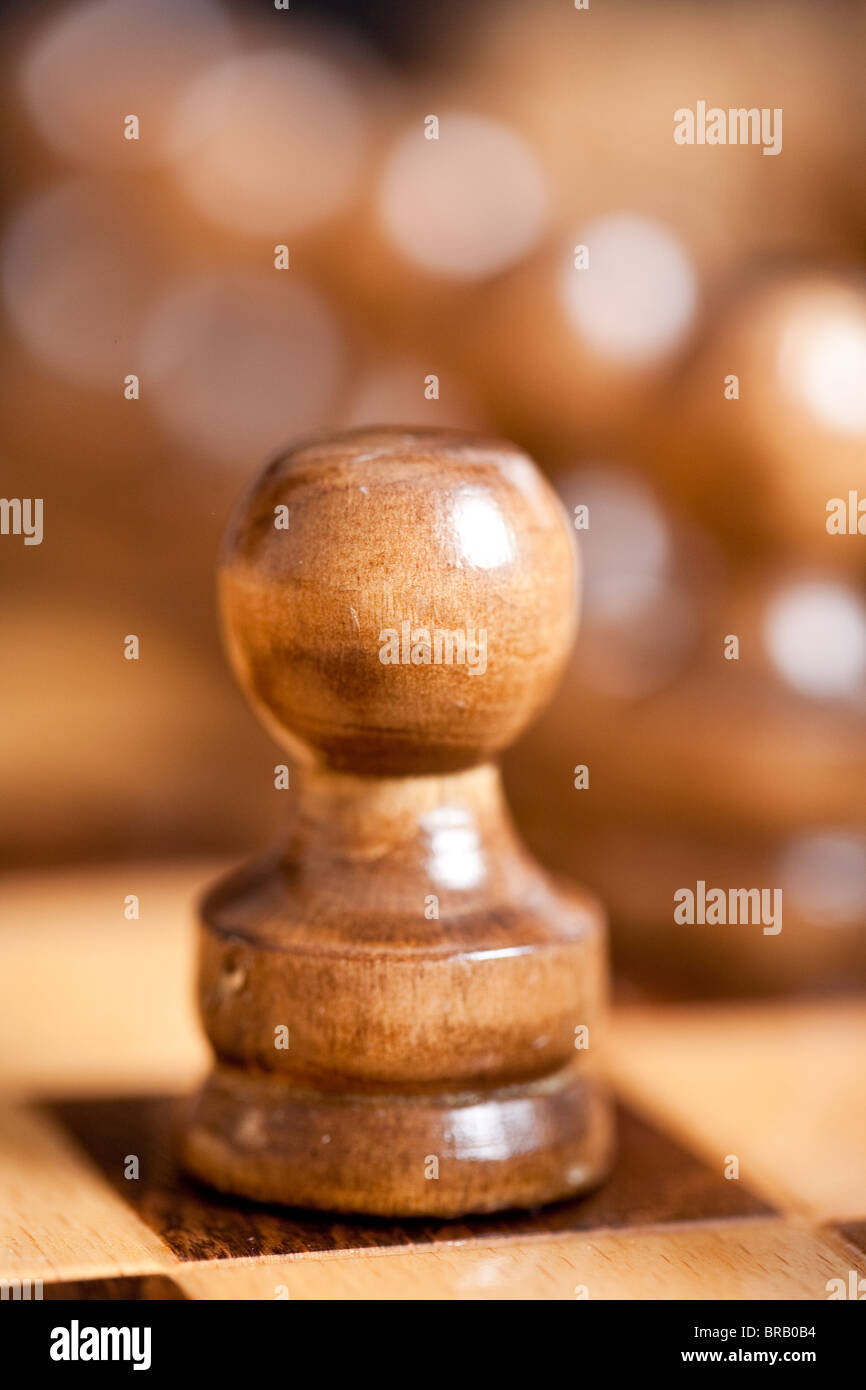 Pawn in front of chess pieces on a board, shallow depth of field Stock ...