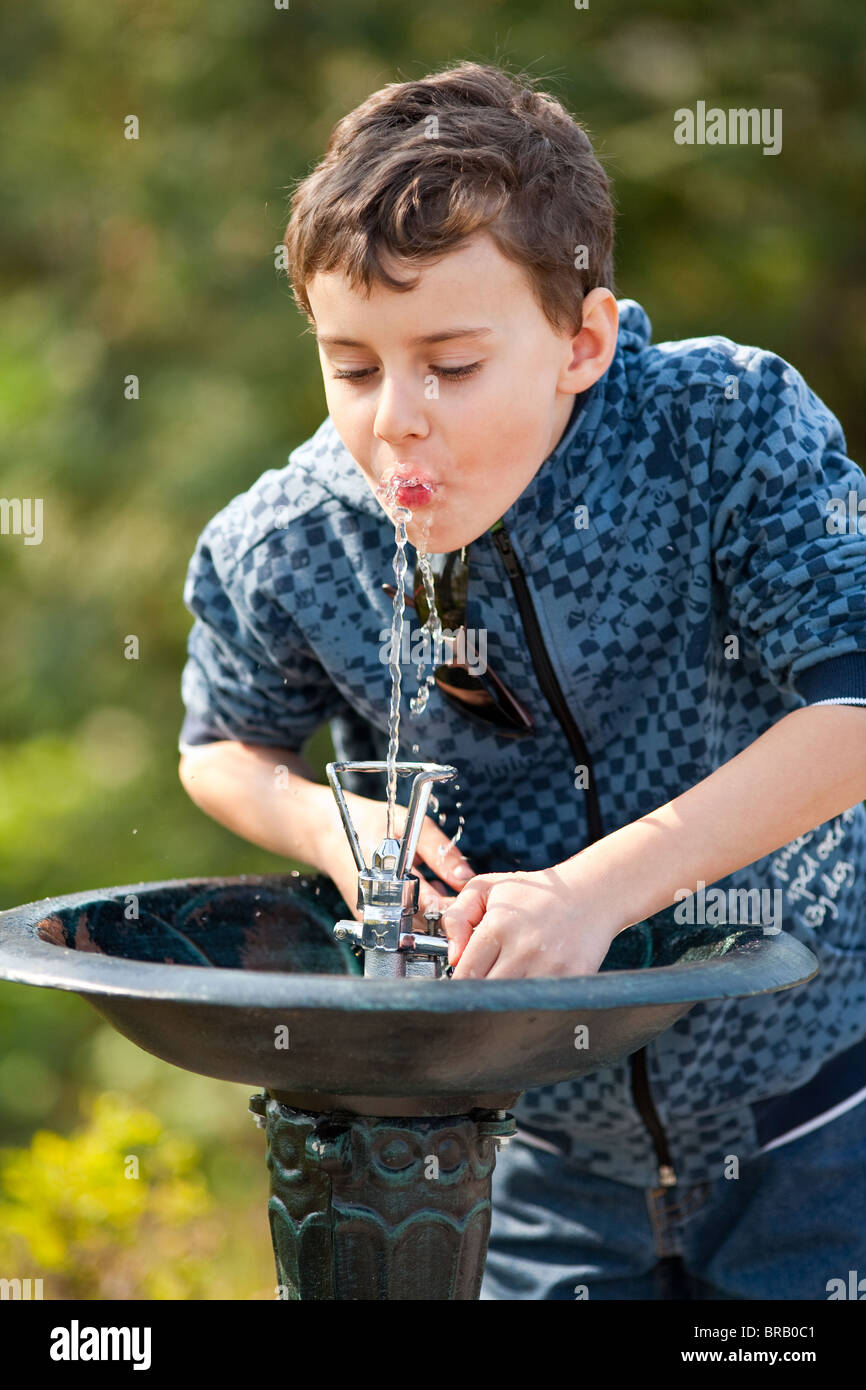 Little boy drinking water from a sprinkler in a park Stock Photo - Alamy
