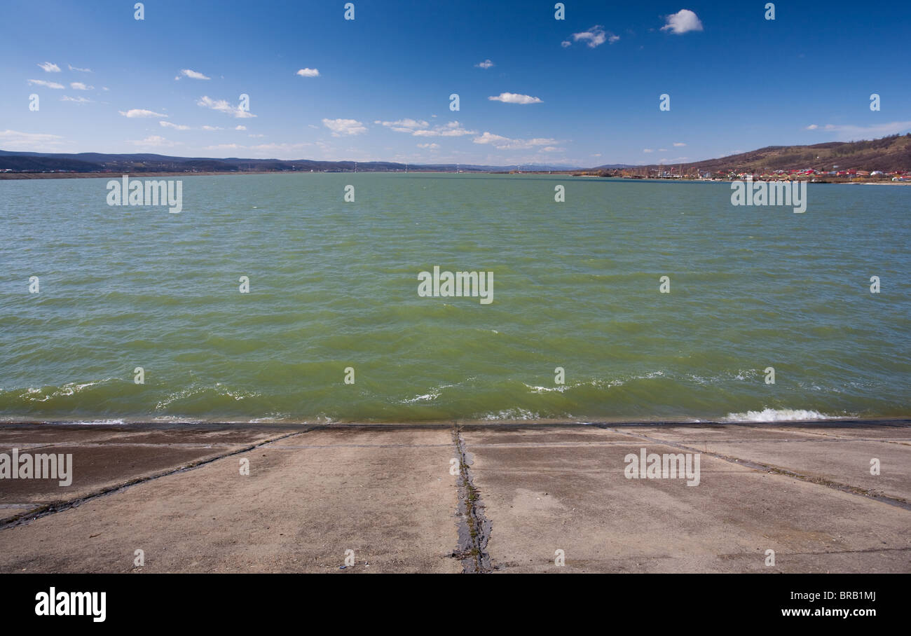 Landscape with a dam or barrage near a village and hills in the ...