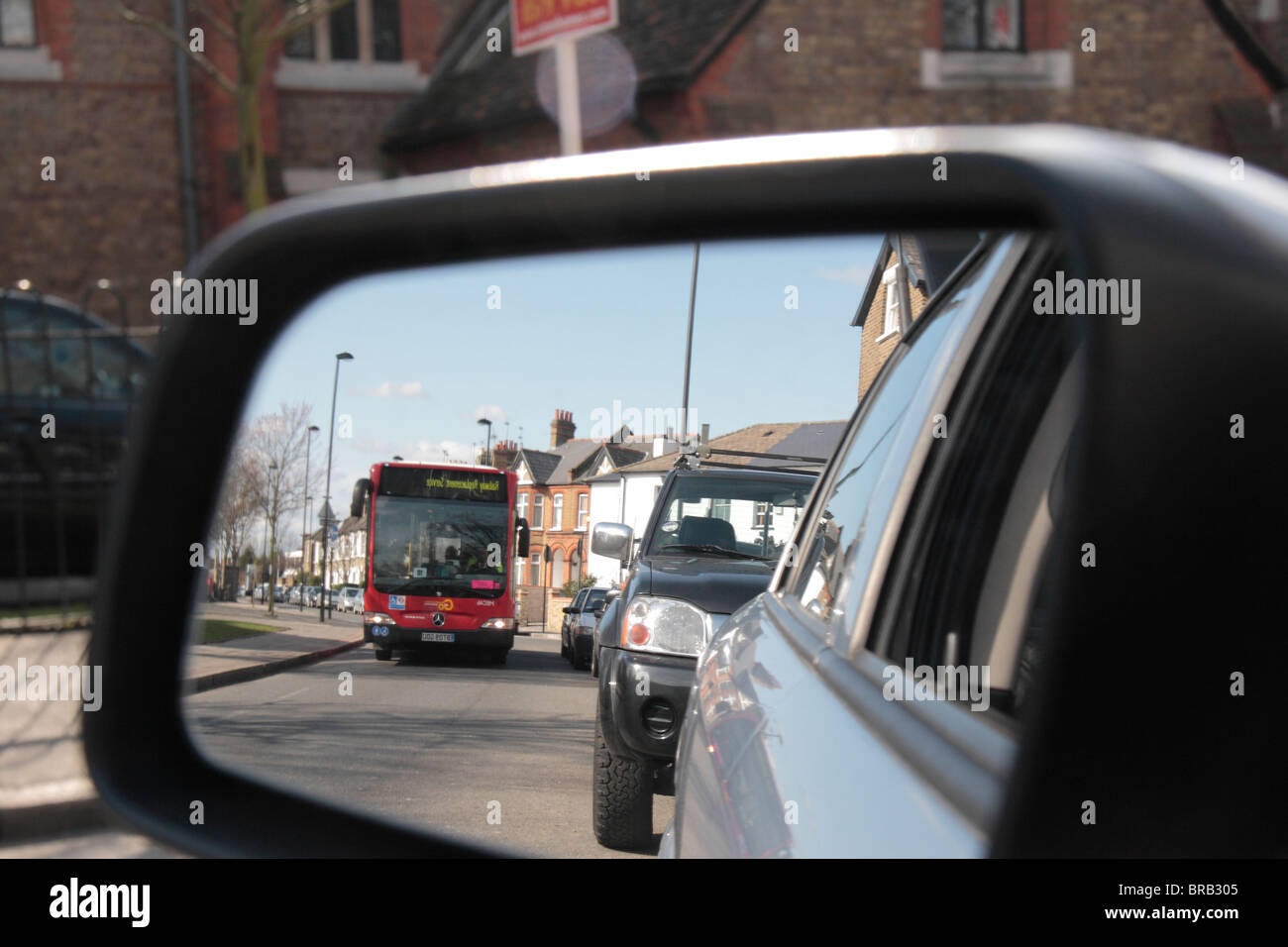 The reflected view of a London Bus coming up behind a parked car in ...