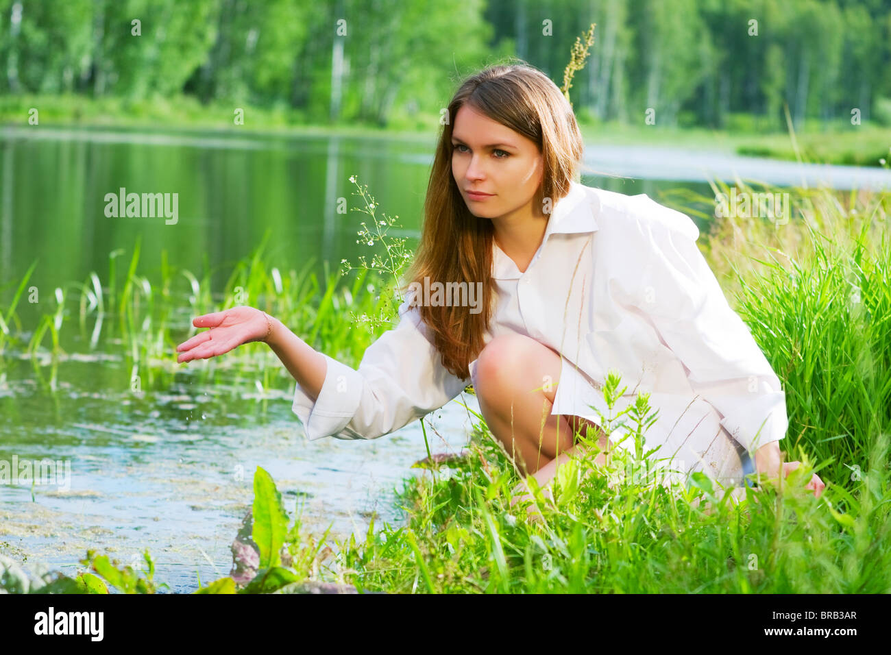 Young woman by the lake Stock Photo - Alamy