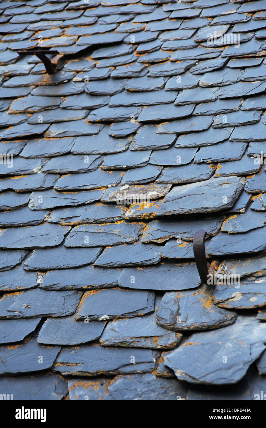 Hooks on traditional wet slate roof for holding wooden beams on a barn ...