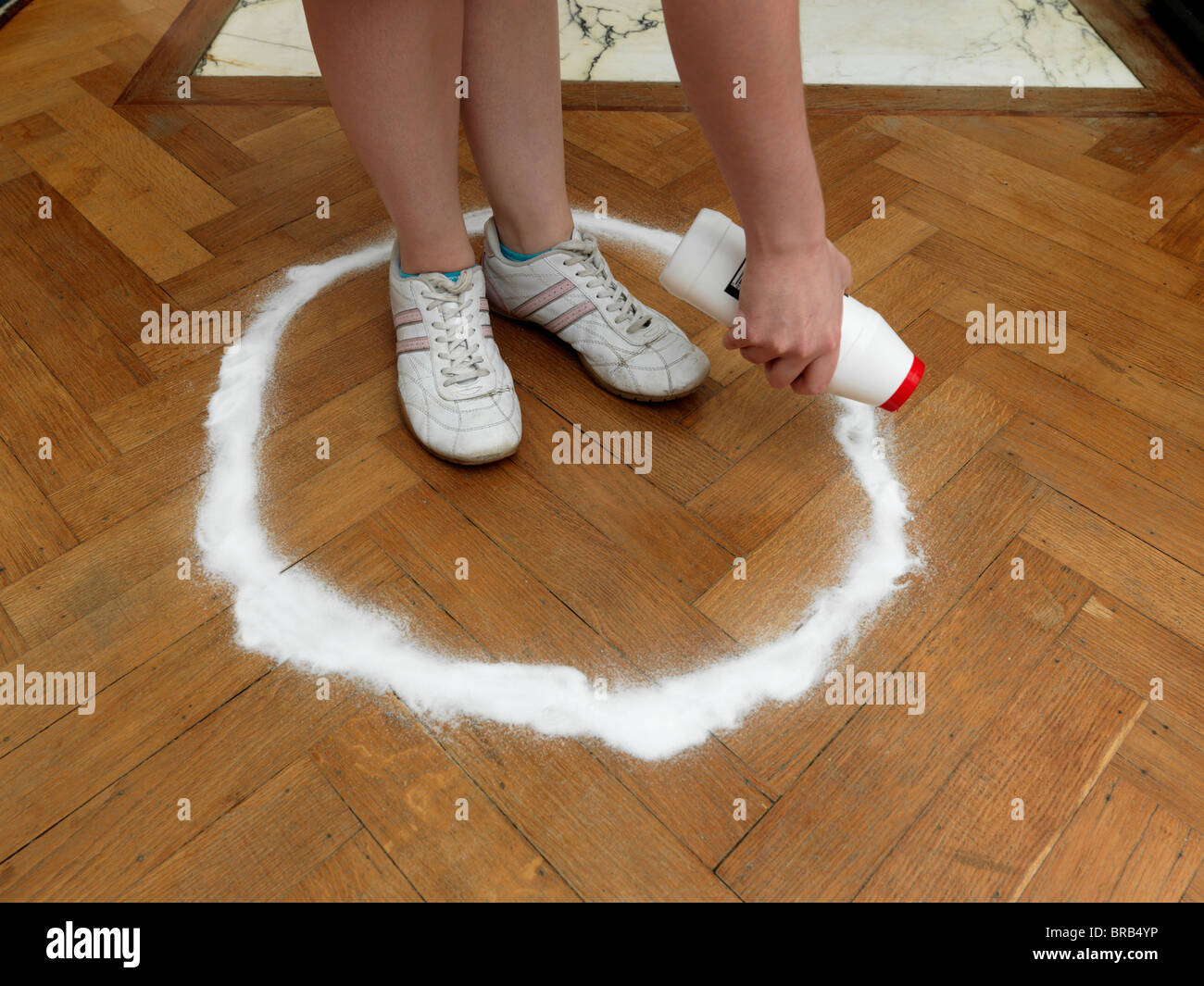 A Caucasian woman sprinkling a salt circle around herself Stock Photo ...