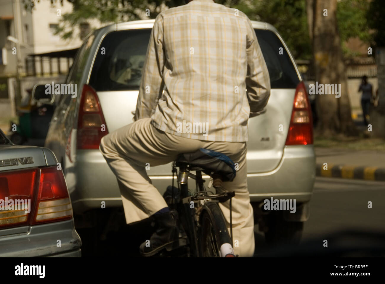 Man cycling behind car in New Dehi, India Stock Photo - Alamy