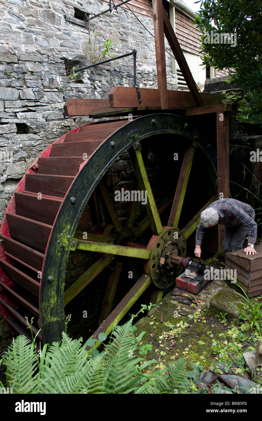 Andrew Parry applying grease to the axle of the waterwheel at Felin ...