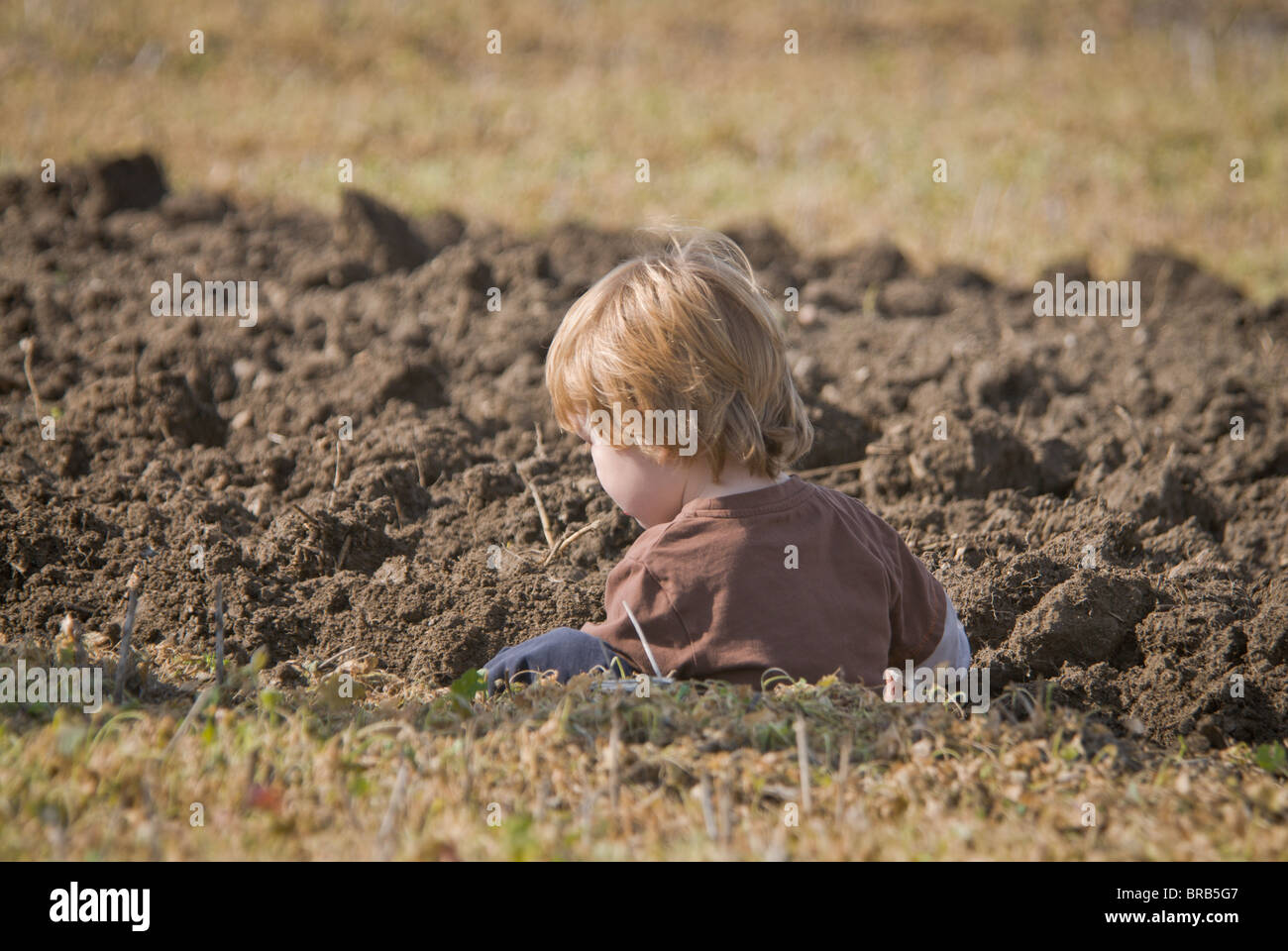 Child sitting in mud Stock Photo - Alamy