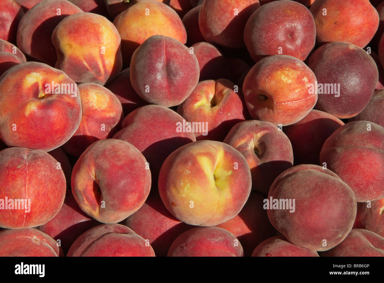Pile of sun lit peaches at the farmers market Stock Photo - Alamy