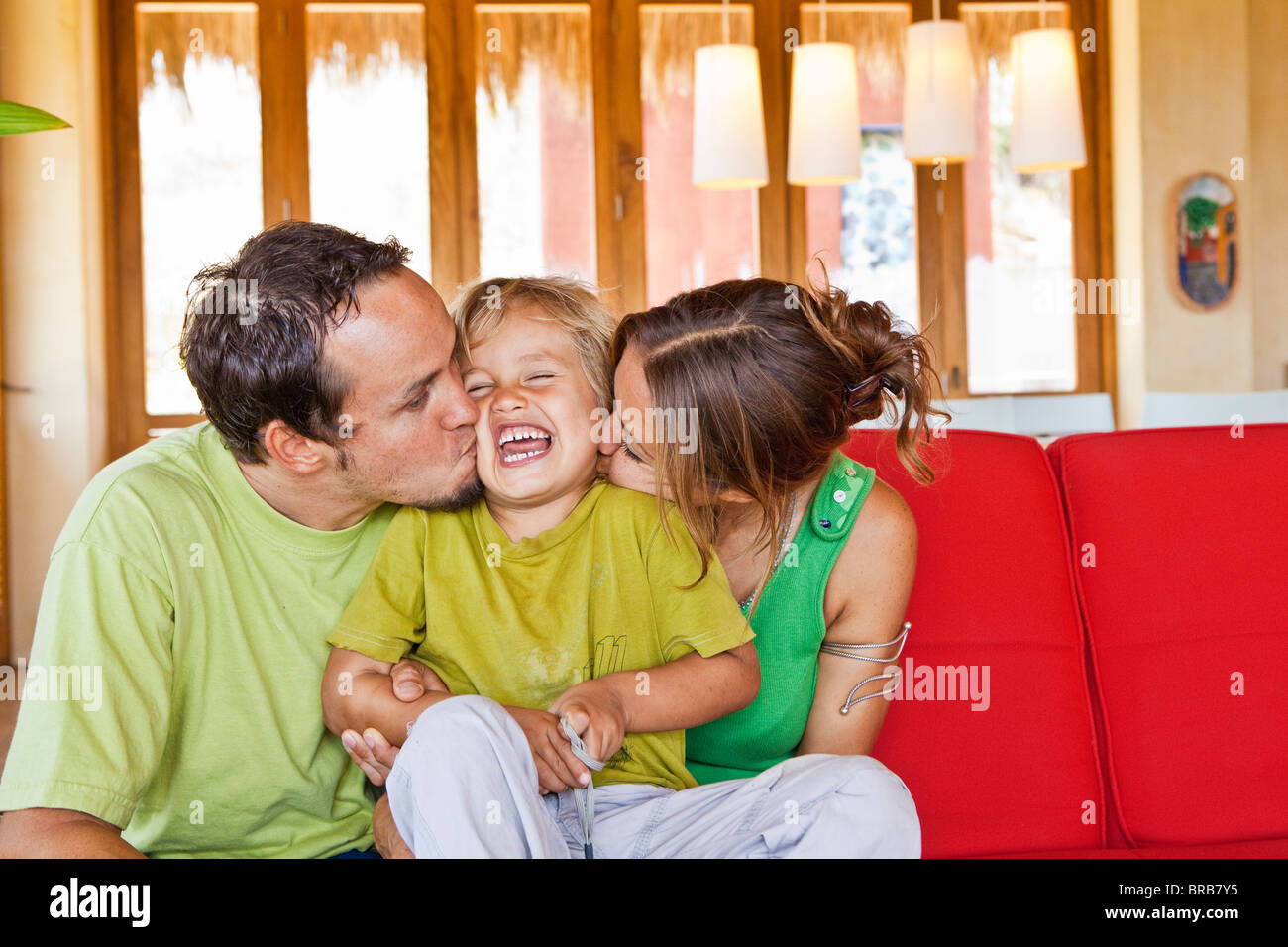 family cuddling on sofa Stock Photo - Alamy