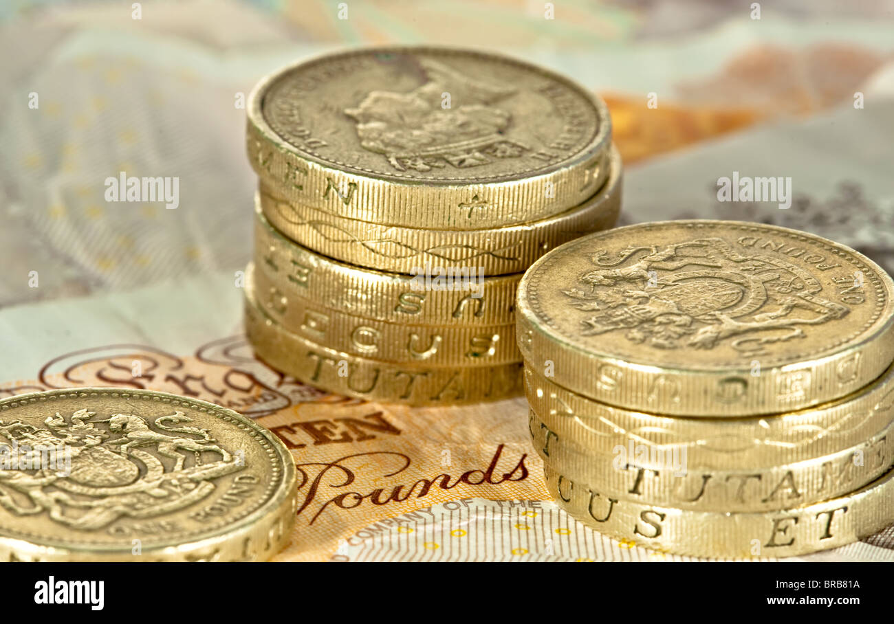 A pile of British pound coins on ten pound notes Stock Photo - Alamy
