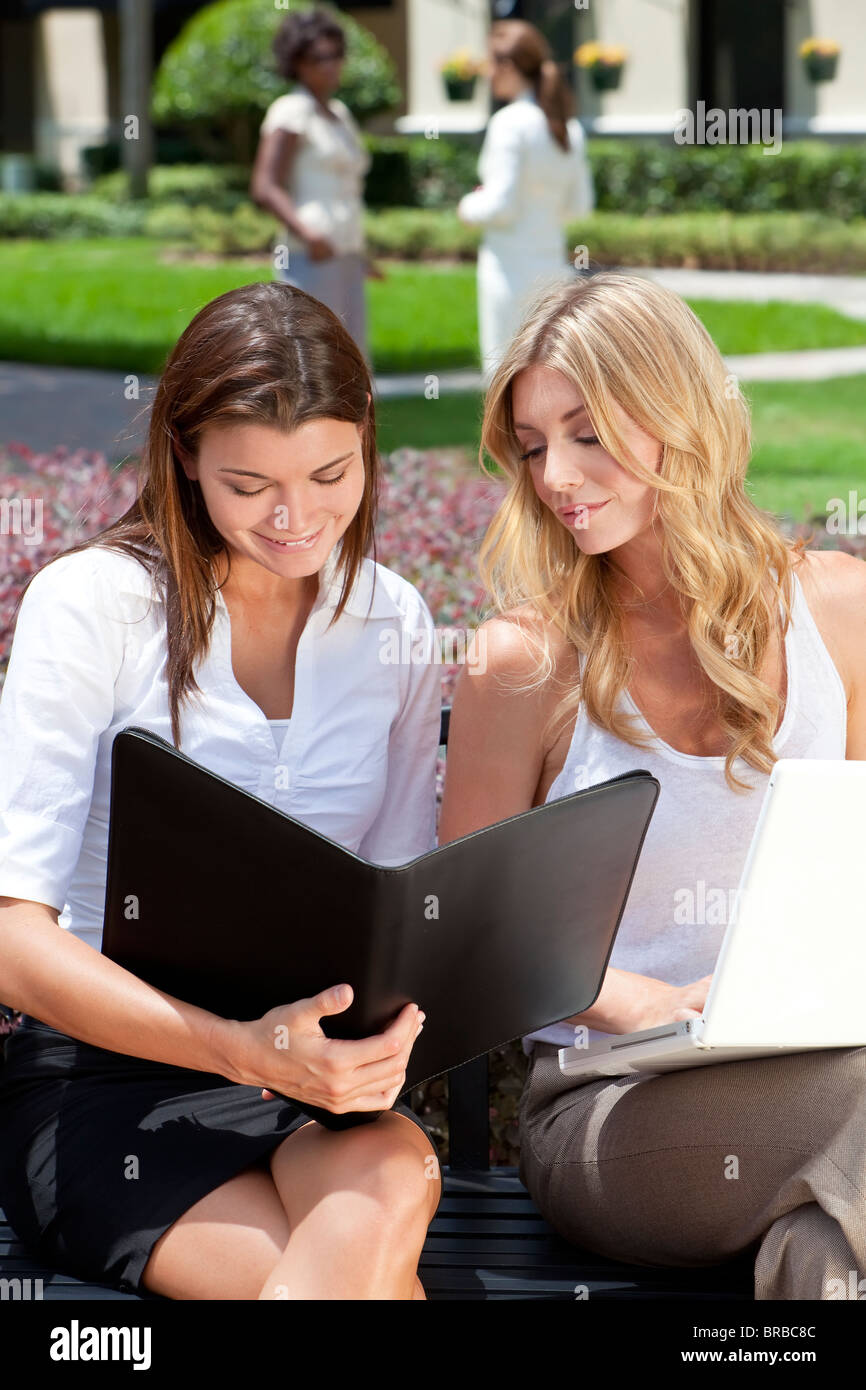 Two attractive you businesswomen or female executives meeting outside ...