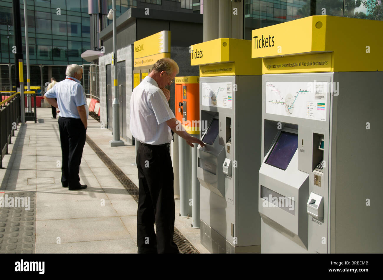 Man at an automatic ticket machine at the Metrolink tram station at ...
