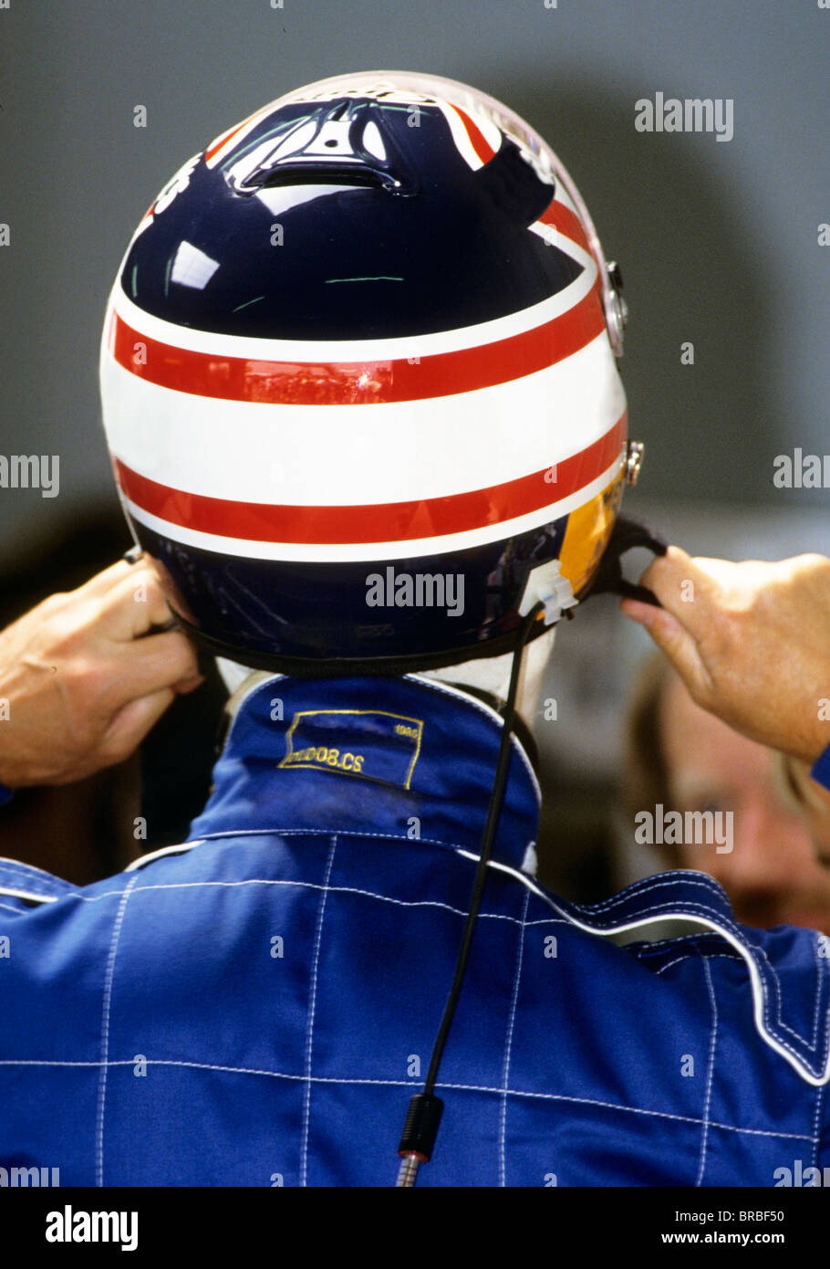 Racecar driver putting on his helmet Stock Photo - Alamy