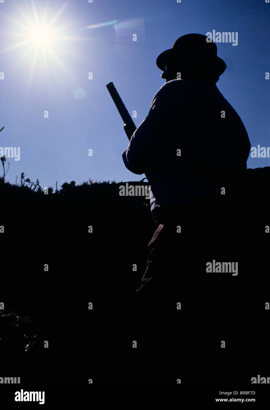 Man holding gun in sunshine Stock Photo - Alamy