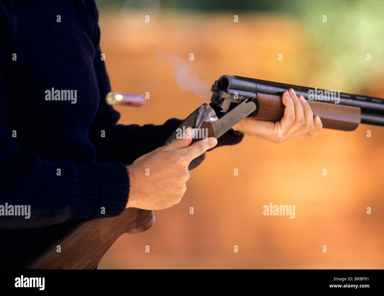 Woman opening shotgun and releasing a shell Stock Photo - Alamy