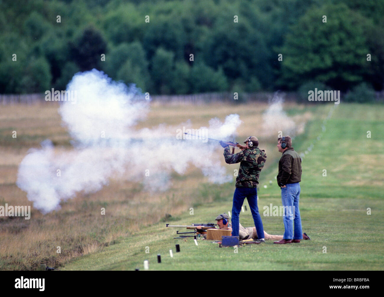 Three men firing rifles at a firing range Stock Photo - Alamy