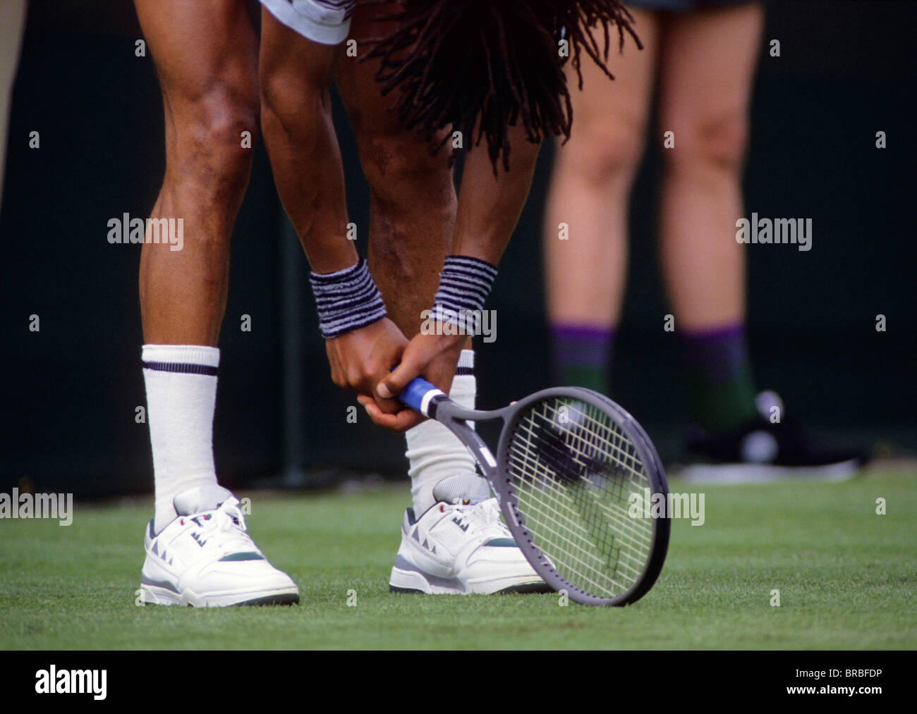 Man hitting tennis racquet on ground Stock Photo - Alamy