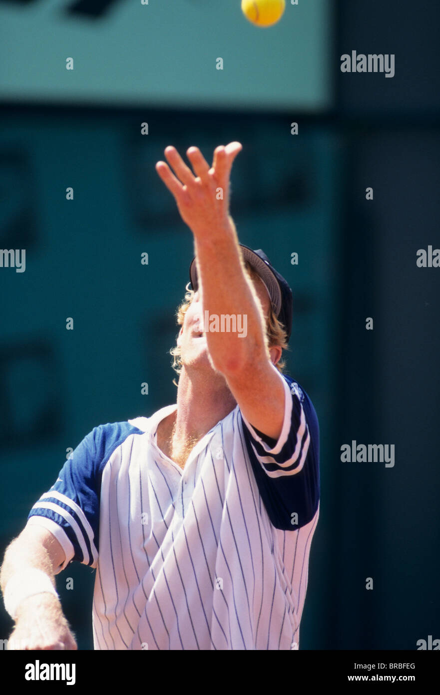 Man throwing tennis ball up in air Stock Photo - Alamy
