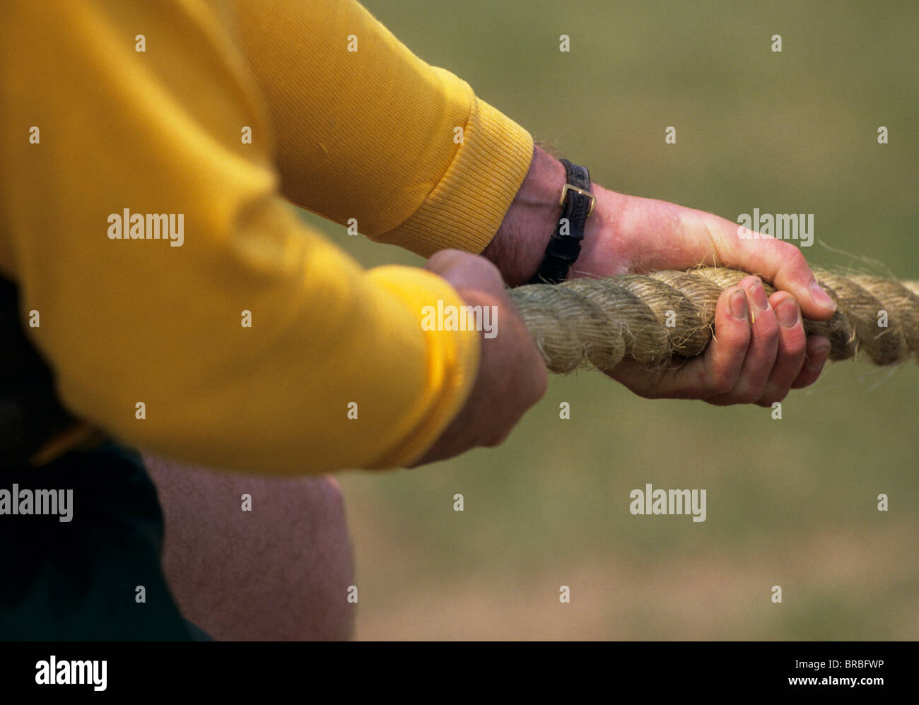 Man pulling on rope in game of tug-of-war Stock Photo - Alamy