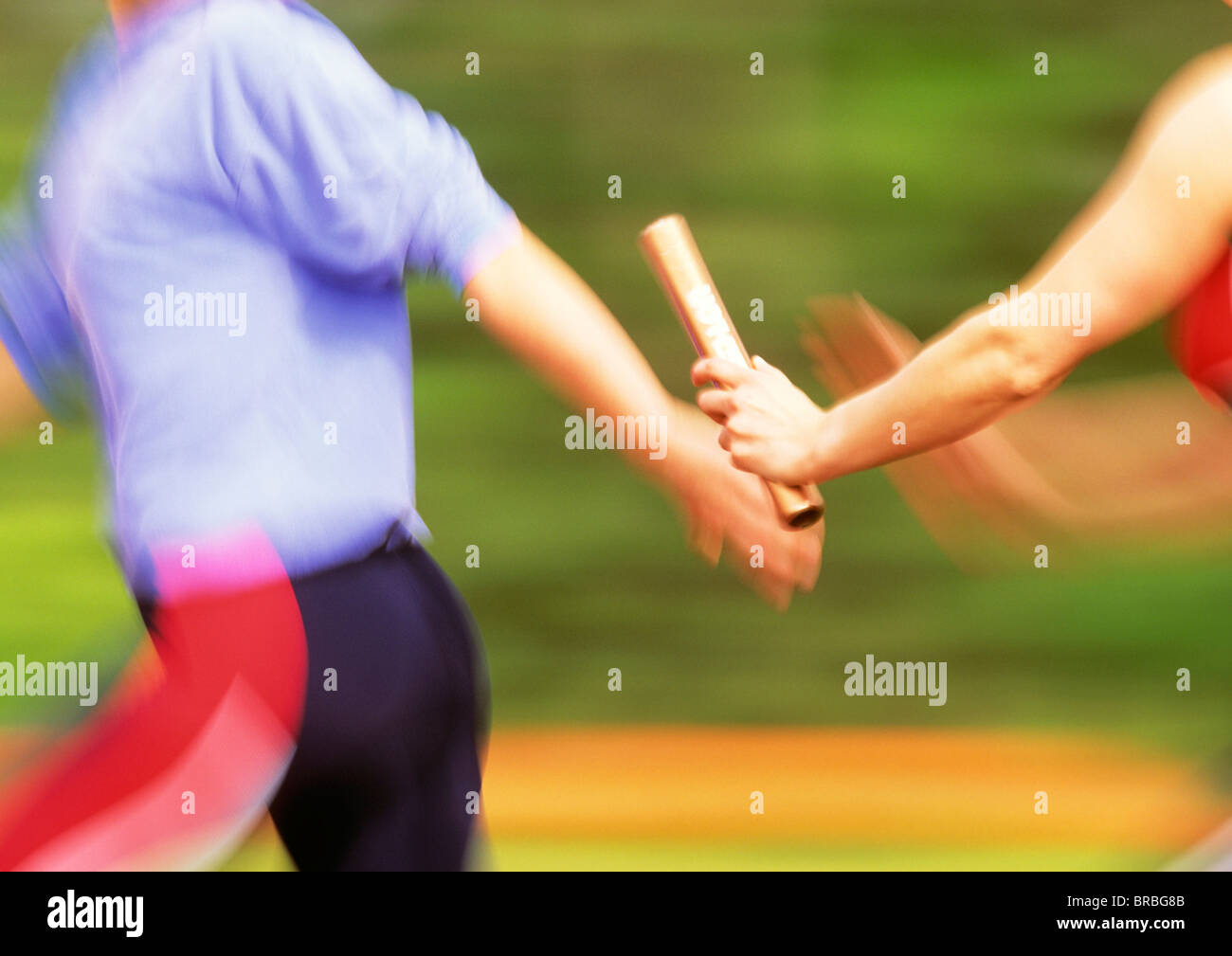Relay runner takes baton from team mate Stock Photo - Alamy