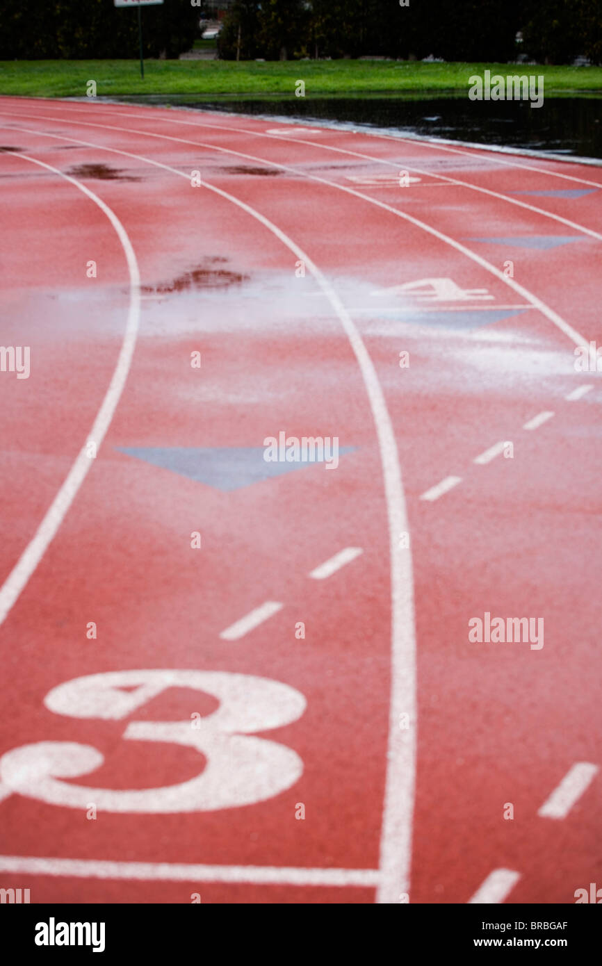 Athletic track lanes at stadium wet with reflection Stock Photo - Alamy