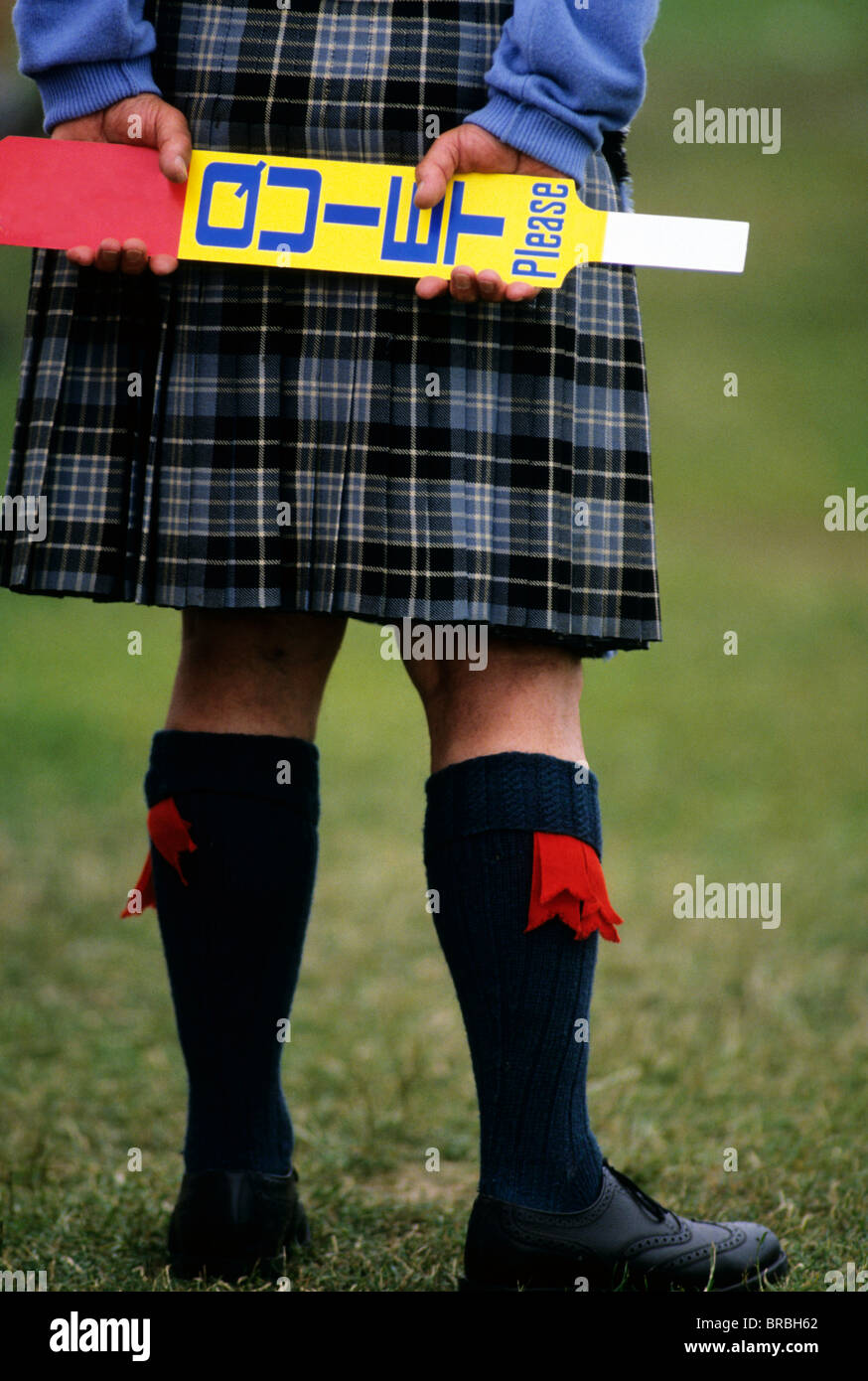 Golf official wearing a kilt holding a quiet sign Stock Photo - Alamy