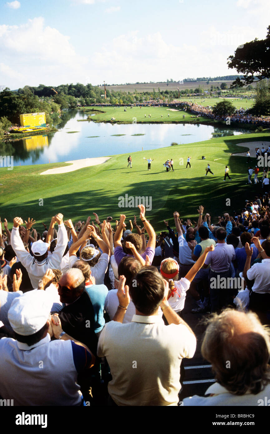 Spectators raise their arms to applaud a golfer who just sunk his put ...