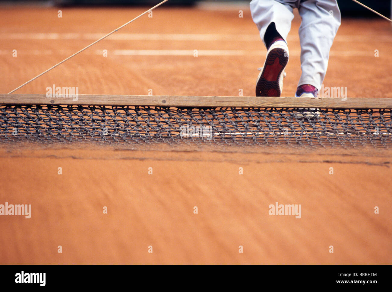 Groundskeeper rakes clay tennis court between sets Stock Photo - Alamy