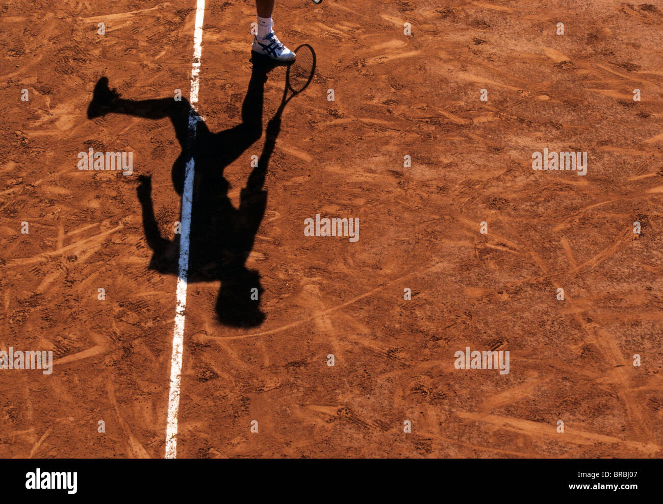 Tennis player serves on a clay court tennis court Stock Photo - Alamy