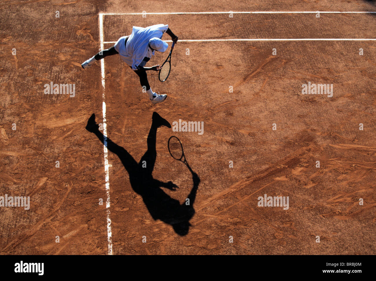 Tennis player serves on a clay court tennis court Stock Photo - Alamy