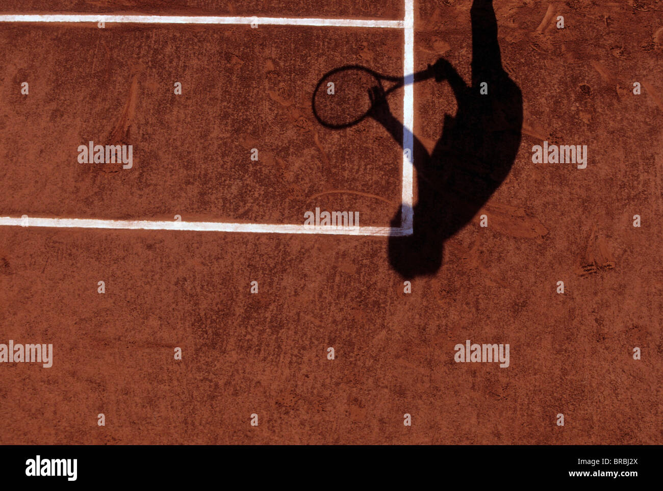 Shadow of a Tennis player serving on a clay court tennis court Stock ...