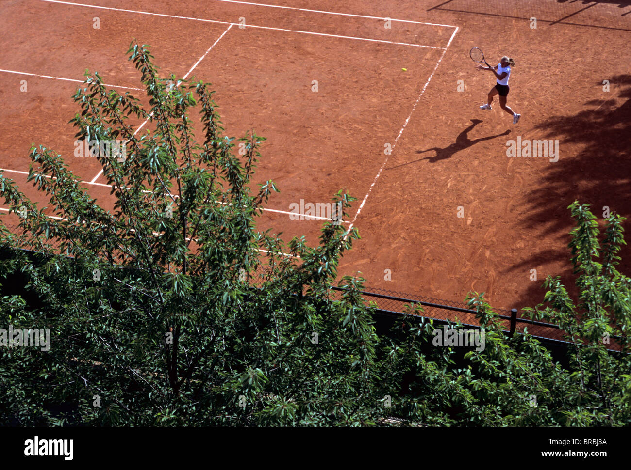 Female Tennis player returns serve on a clay court tennis court Stock ...