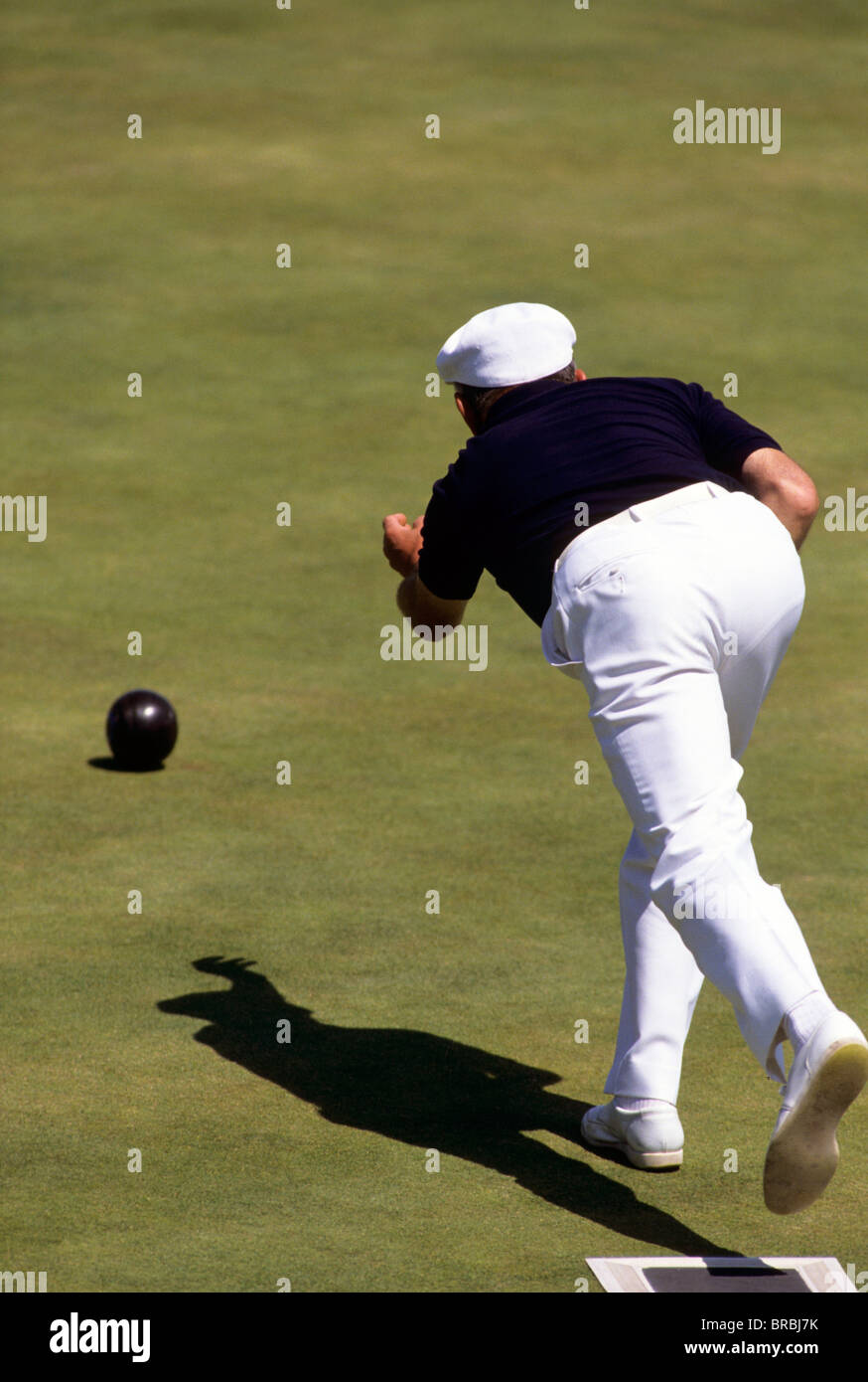 Man bowls in lawn bowls game from foot mat Stock Photo - Alamy