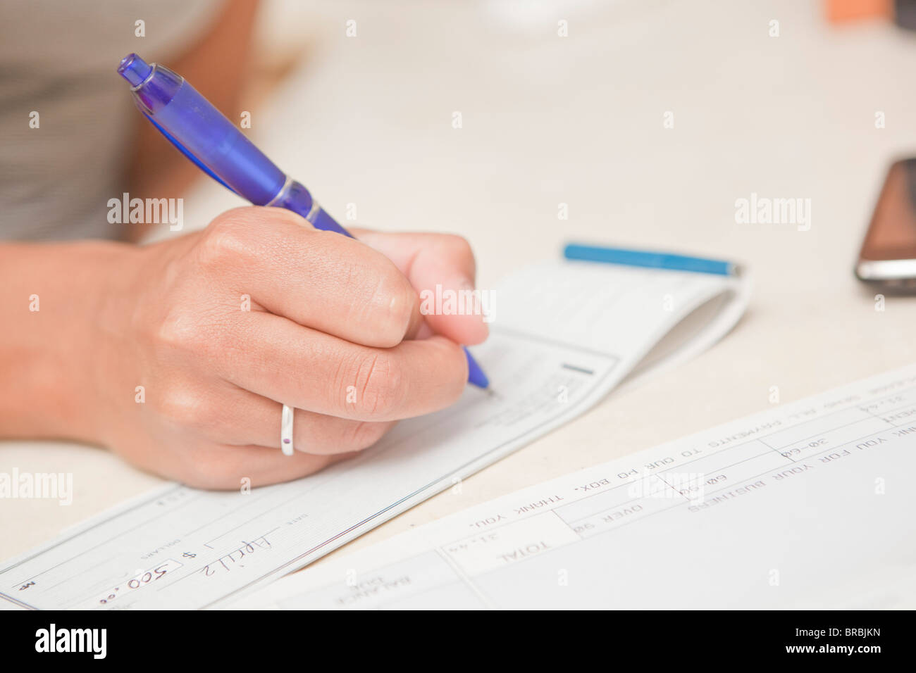 woman's hand writing checks Stock Photo - Alamy