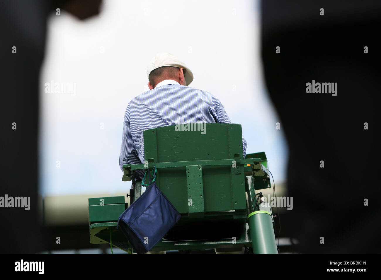 Tennis official sitting in umpires chair Stock Photo - Alamy