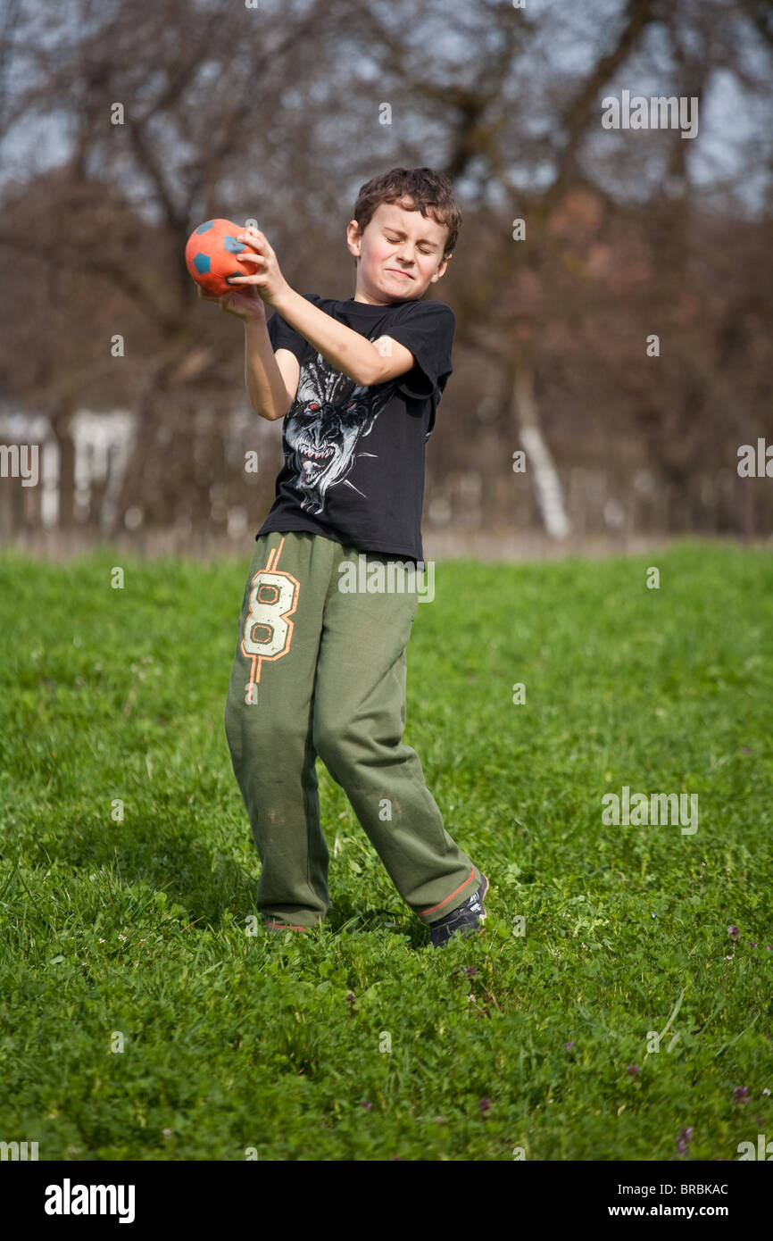 Funny boy making faces while catching the ball outdoor Stock Photo - Alamy