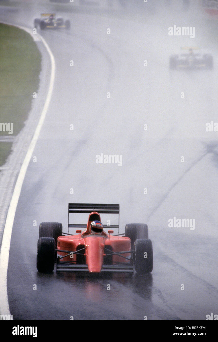 Formula one racers driving through rain soaked track Stock Photo - Alamy