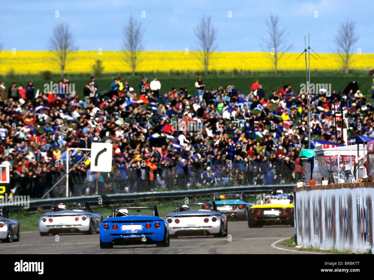Group of race cars driving around a corner Stock Photo - Alamy