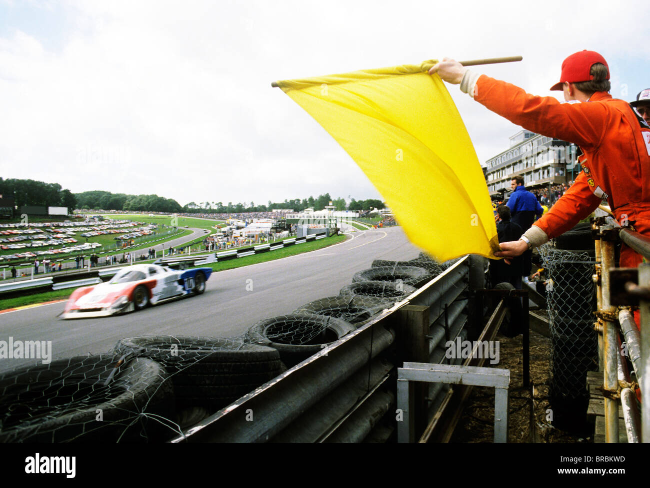 Official waving yellow caution flag to racers Stock Photo - Alamy