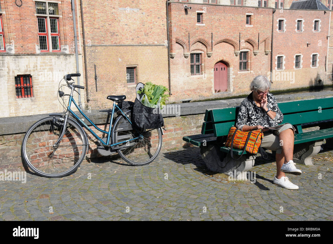 BELGIUM. WOMAN AND BICYCLE IN THE MEDIEVAL TOWN OF BRUGES IN FLEMISH ...